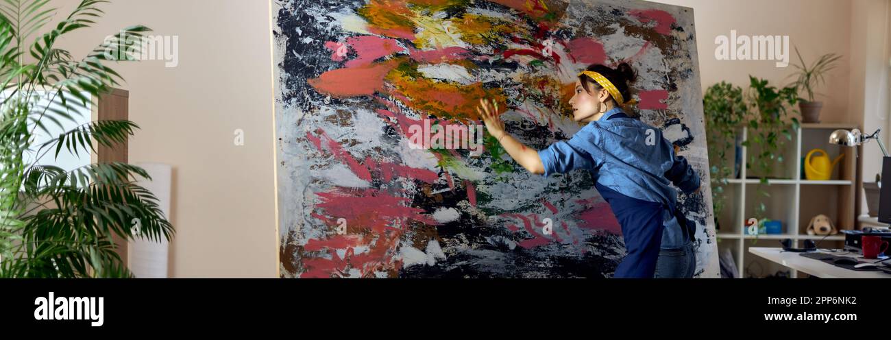 Full length shot of inspired female painter working on a large modern ...
