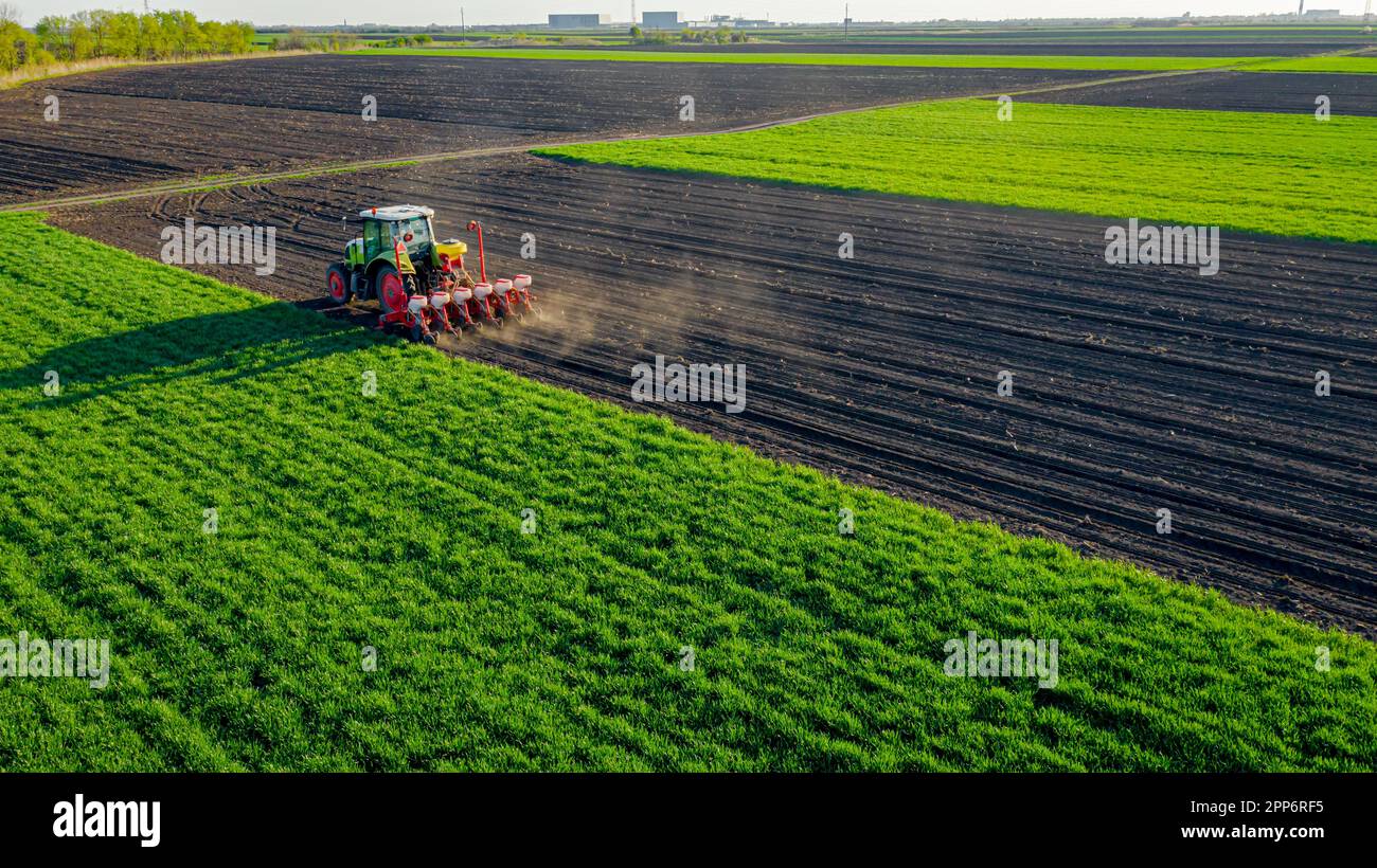 Above view, of tractor as pulling mechanical seeder machine over arable ...
