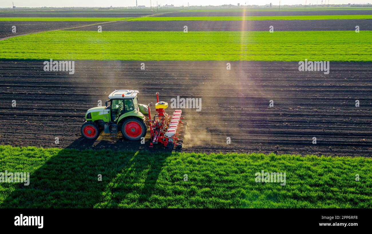 Above view, of tractor as pulling mechanical seeder machine over arable ...