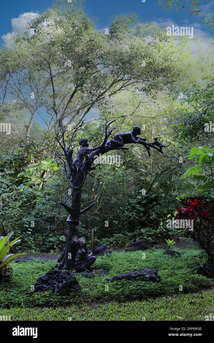 A sculpture of two young boys rescuing a cat from a tree, with a young ...