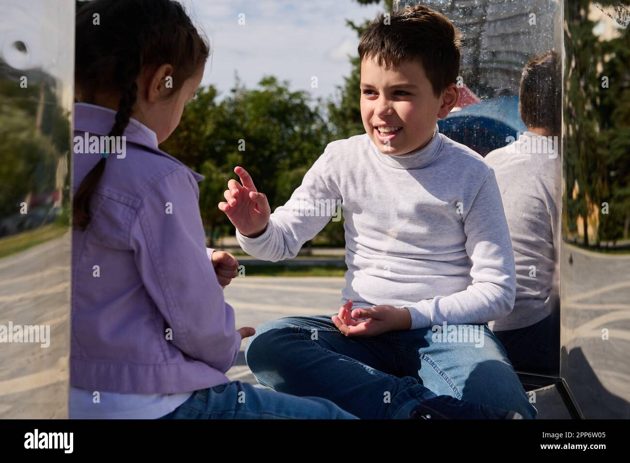 Lovely pre teen boy talking with his little sister while relaxing ...