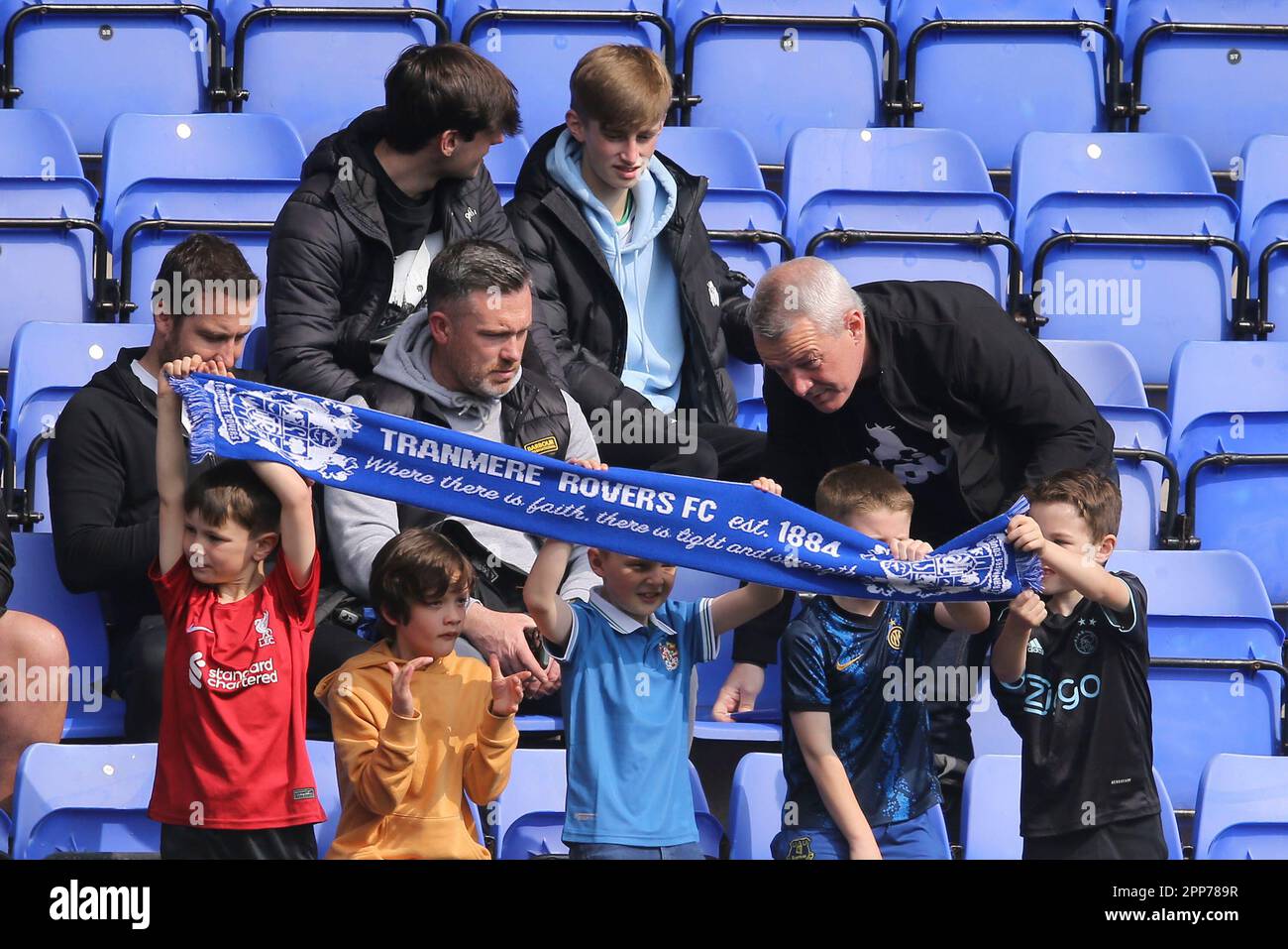 Birkenhead, UK. 22nd Apr, 2023. Young Tranmere Rovers fans with a large ...