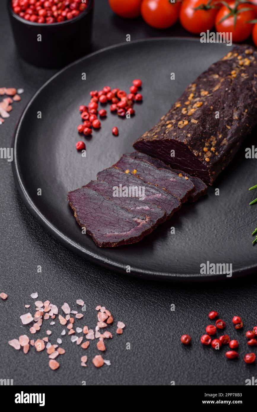 Delicious smoked Armenian basturma with spices and herbs sliced on a ...