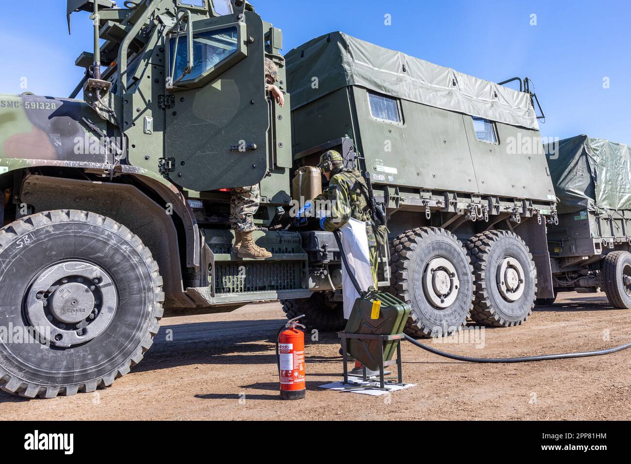 A Swedish Northern Military District soldier refuels a Medium Tactical ...