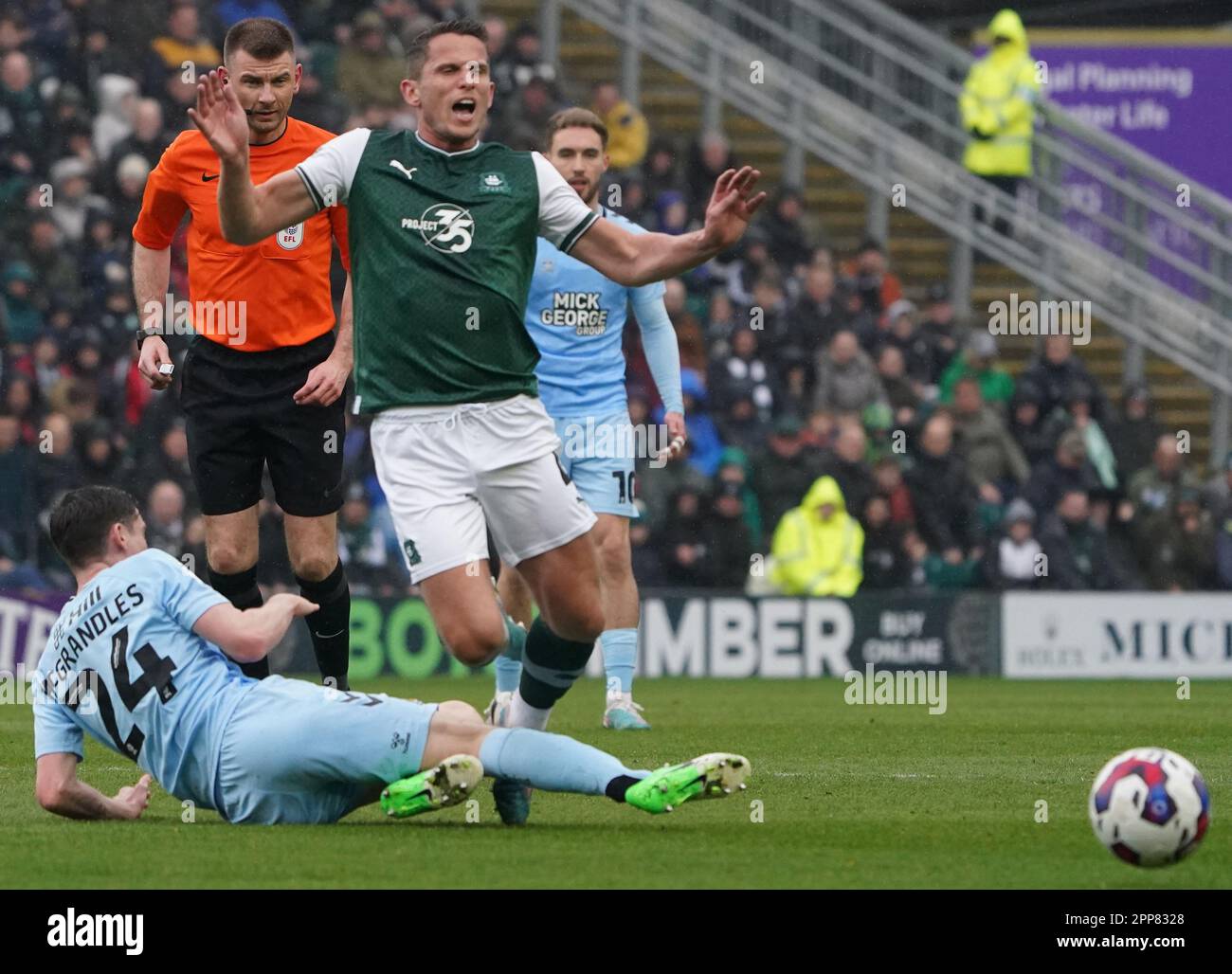 PLYMOUTH, ENGLAND - APRIL 22: Cambridge's Conor McGrandles fouling Plymouth's Jordan Houghton ...