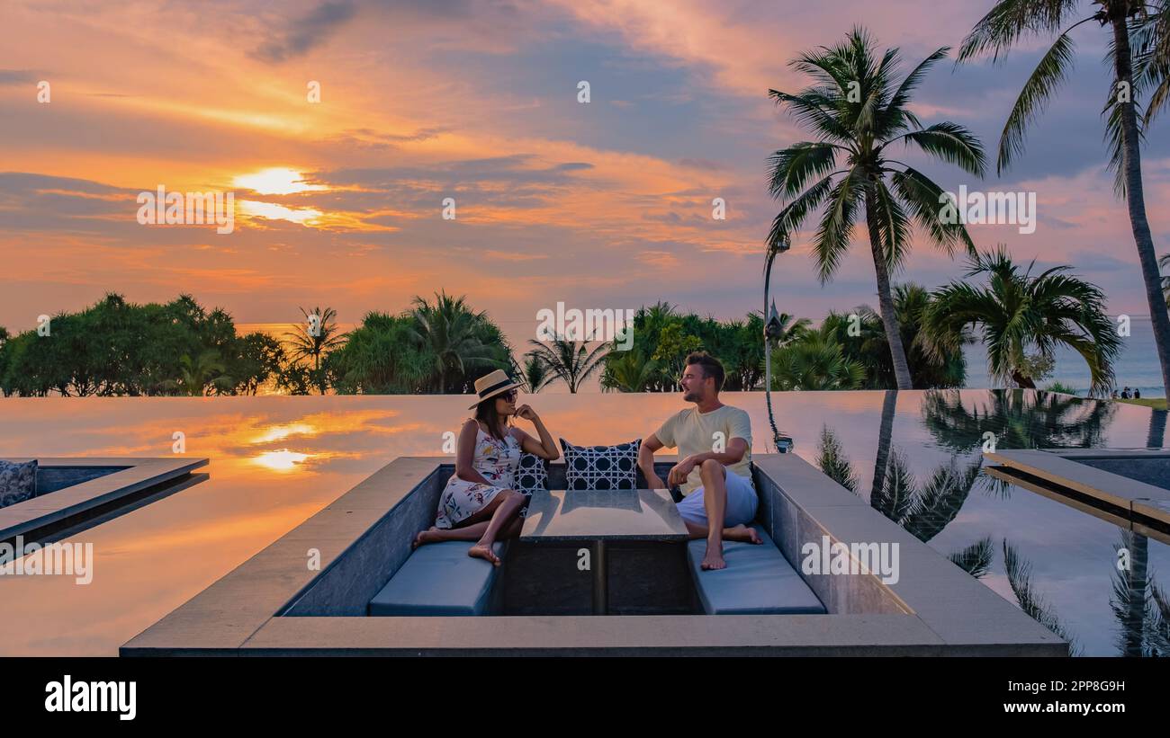 couple watching the sunset in an infinity pool on a luxury vacation in ...
