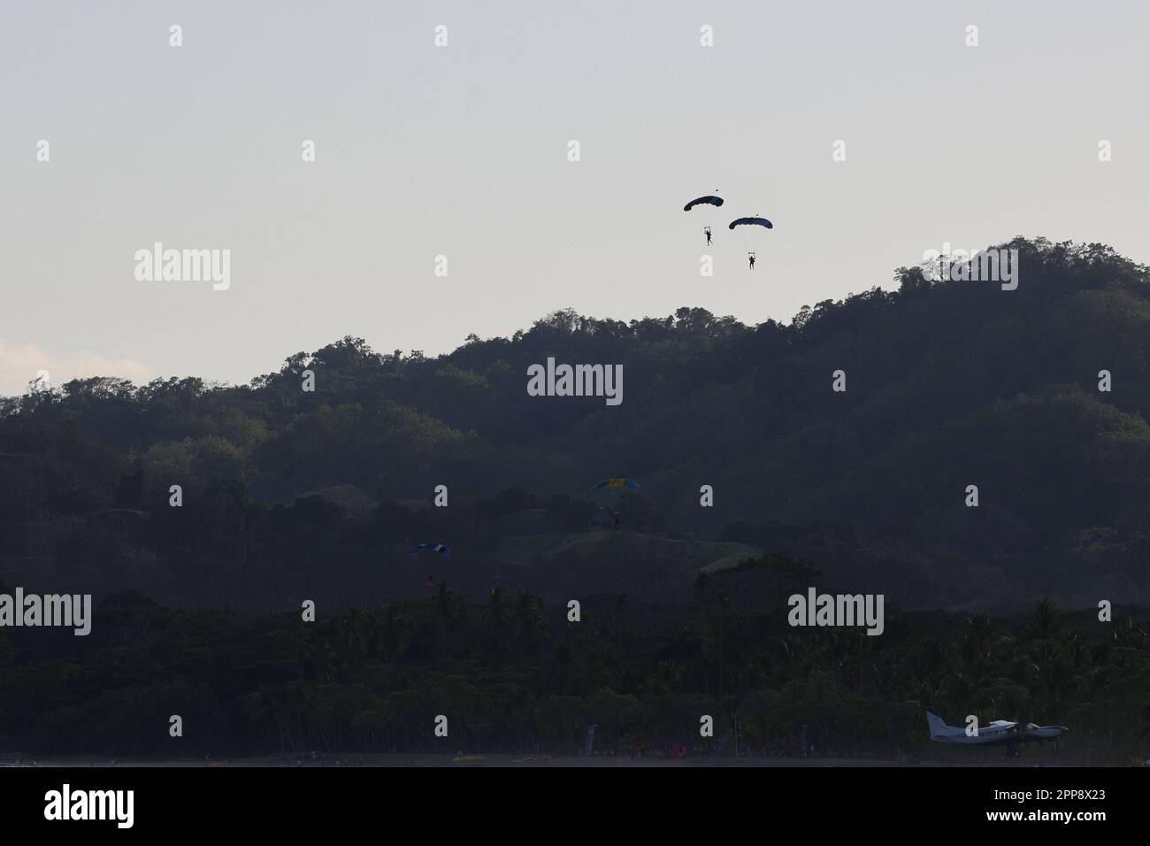 Skydivers soar through the air with a stunning mountain backdrop and a ...