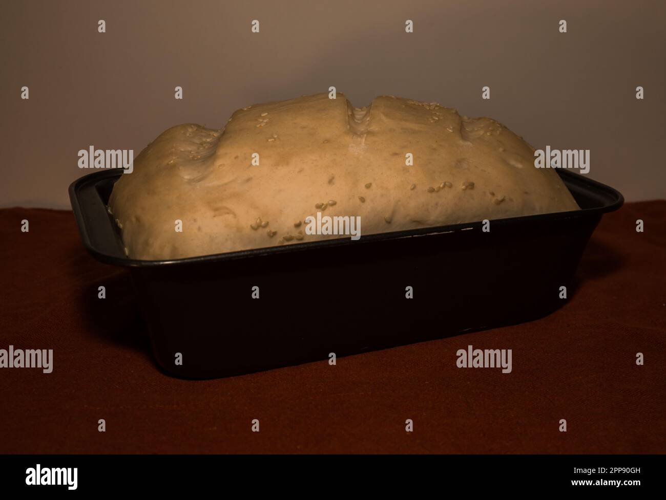 Homemade yeast bread from white flour in a square baking dish. The ...