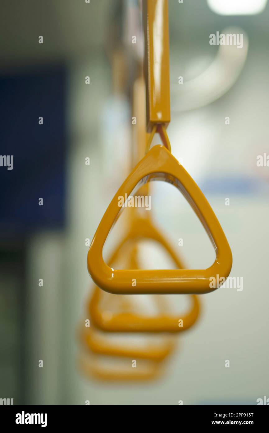 Close up and selective focus of yellow triangle handle bar in the train ...