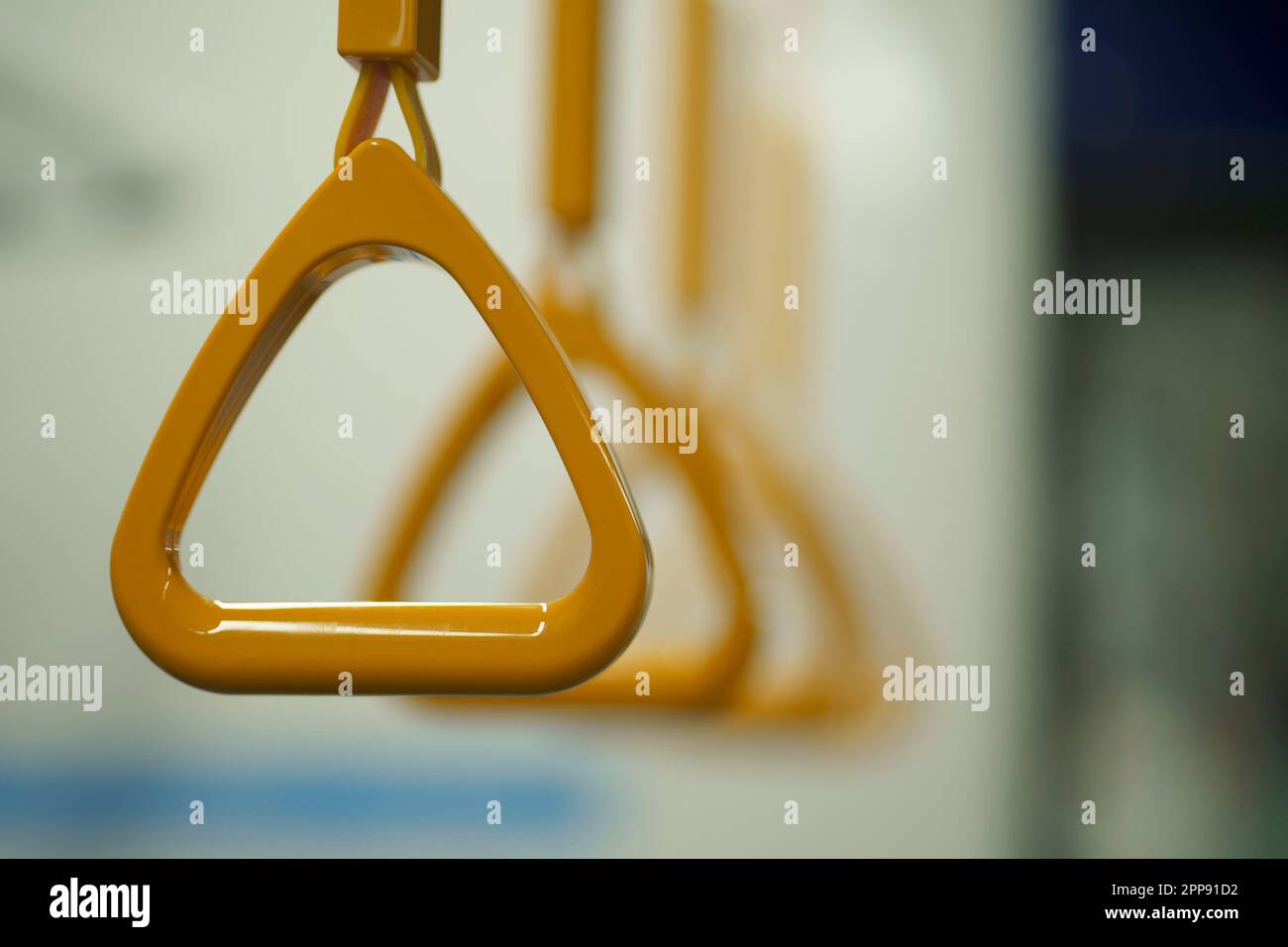 Close up and selective focus of yellow triangle handle bar in the train ...