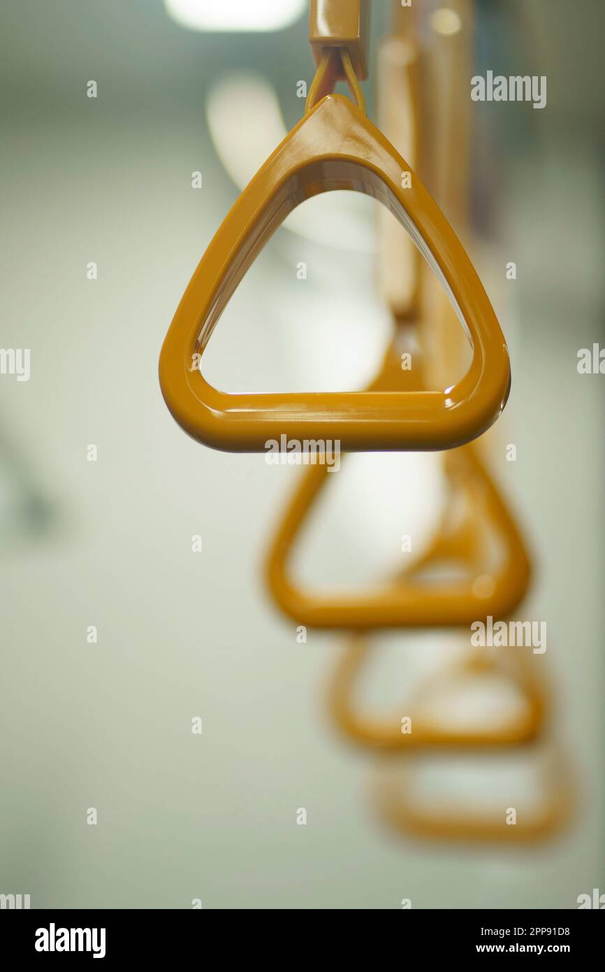 Close up and selective focus of yellow triangle handle bar in the train ...