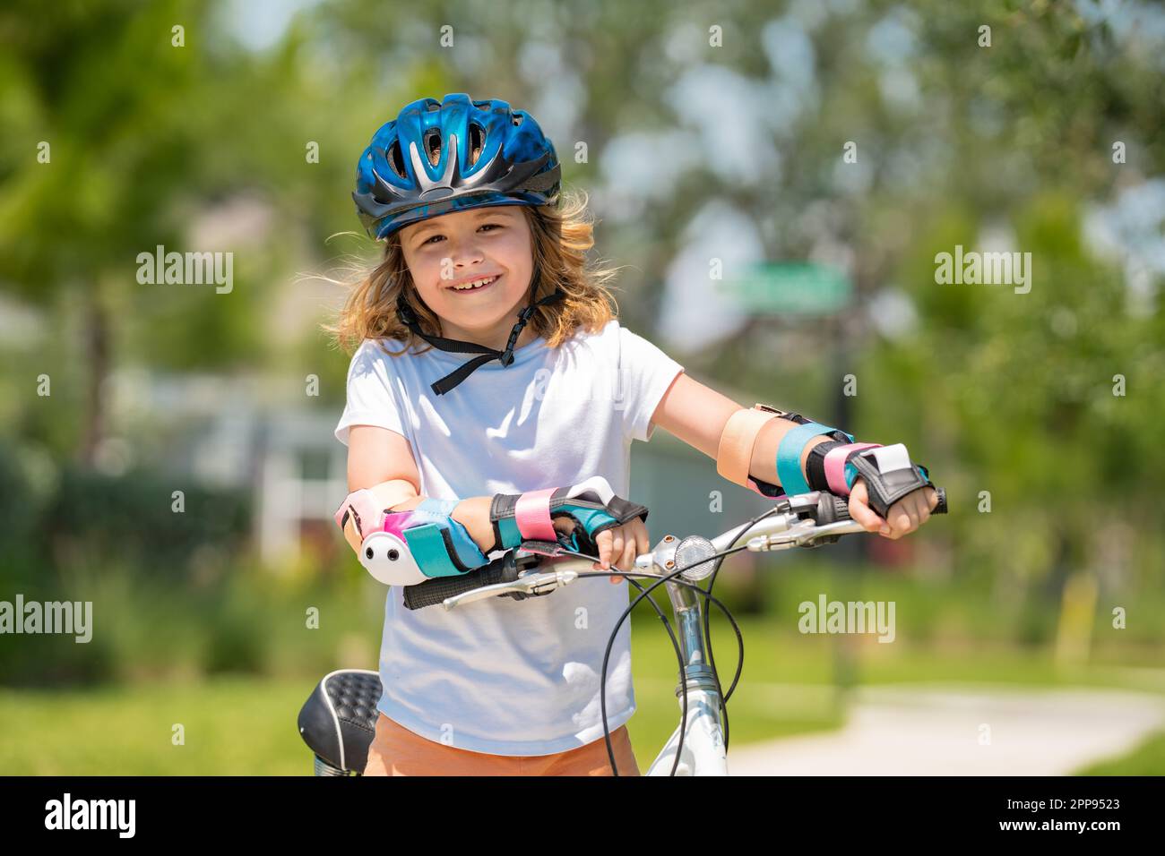 Little kid boy riding a bike in summer park. Children learning to drive ...