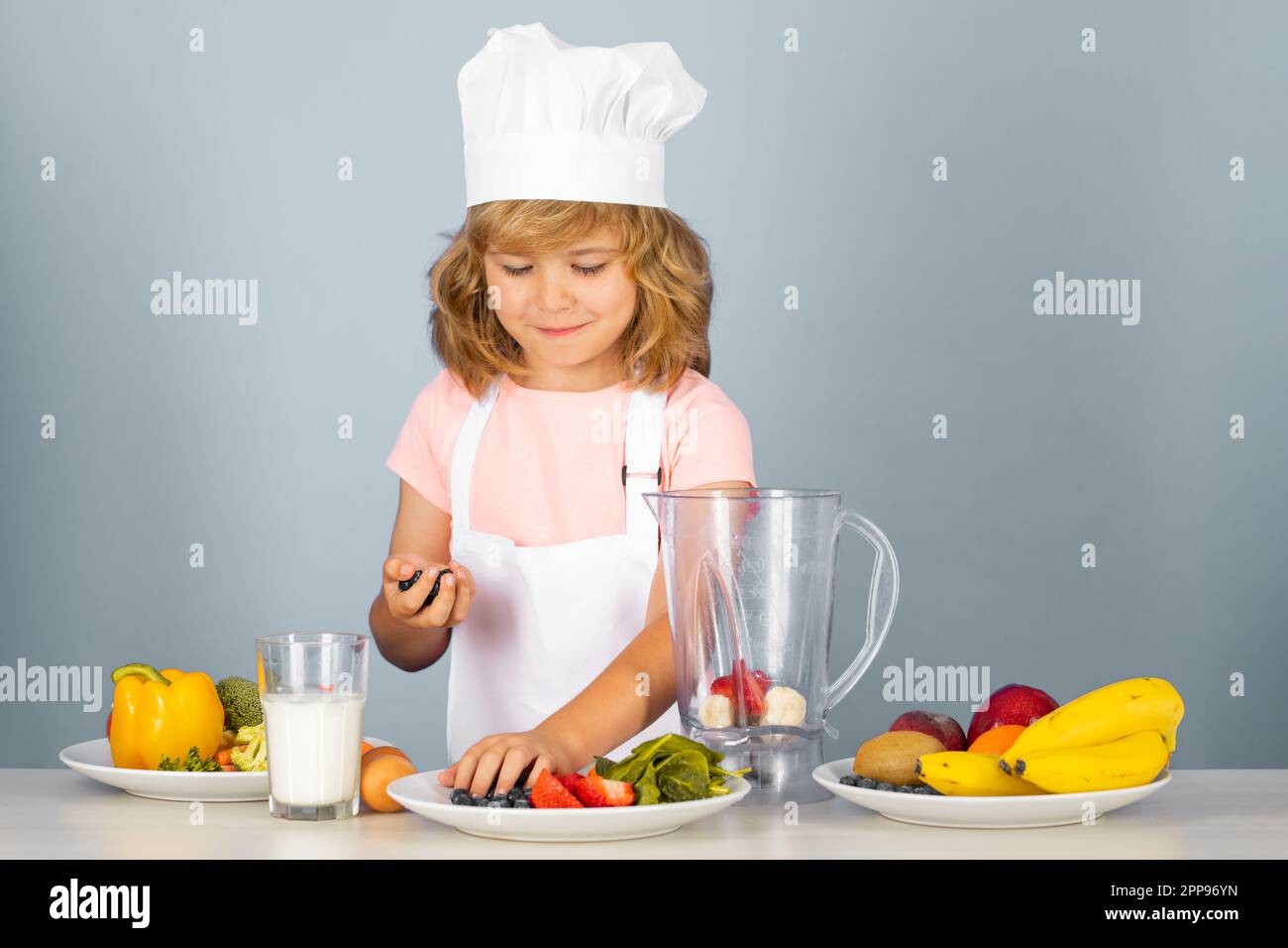 Child chef dressed cook baker apron and chef hat make smoothie isolated ...