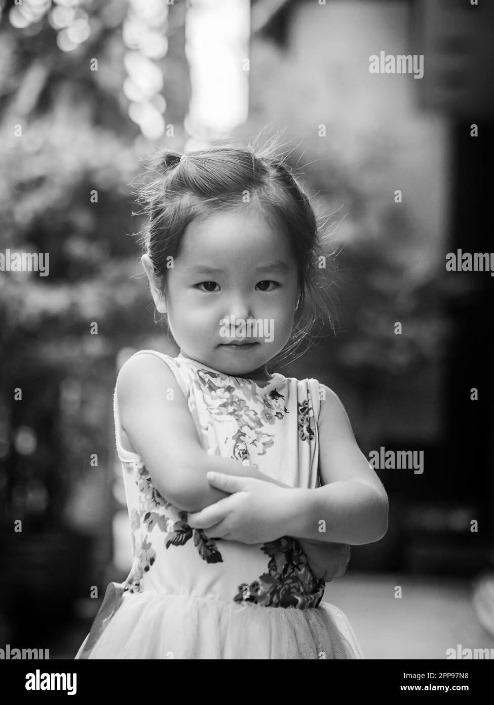 Portrait of a little Asian kid girl with arms crossed acting, black and ...