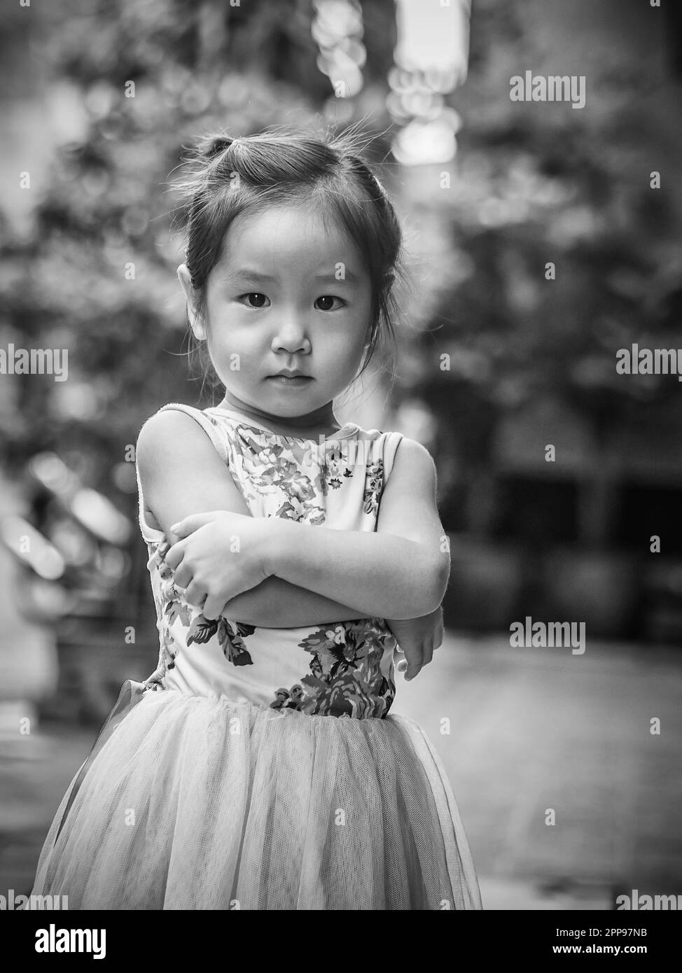 Portrait of a little Asian kid girl with arms crossed acting, black and ...
