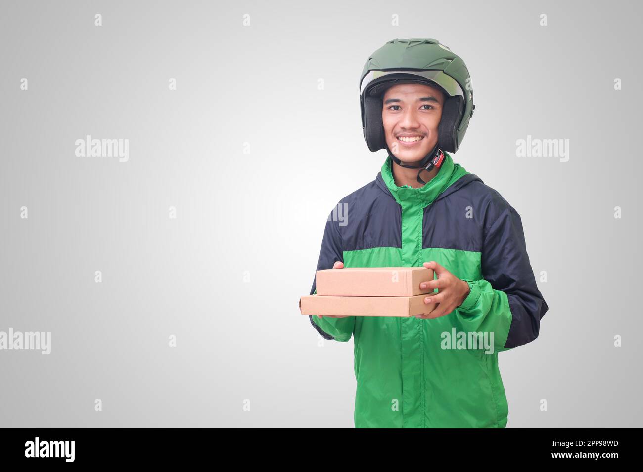 Portrait of Asian online courier driver wearing green jacket and helmet ...