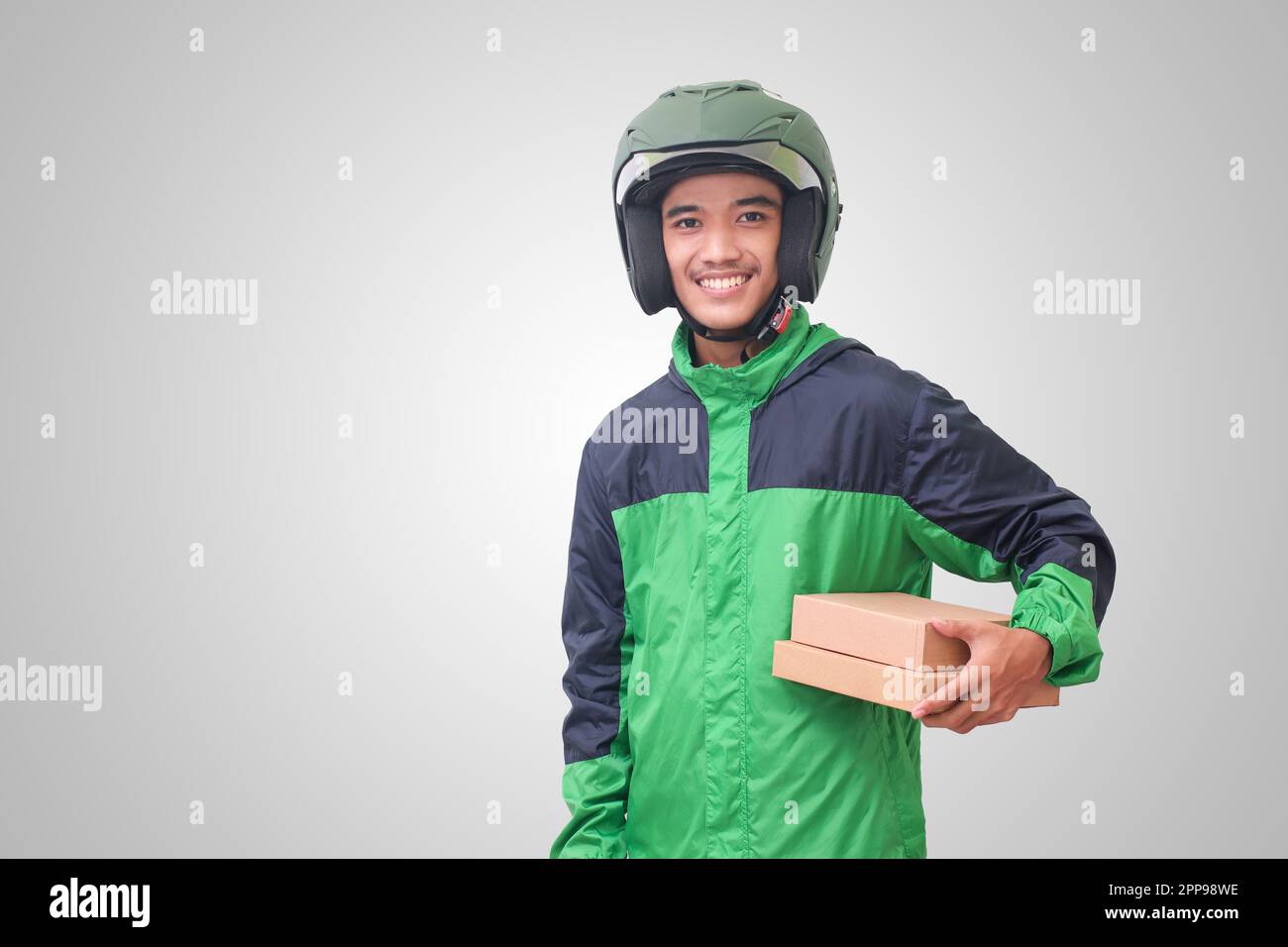 Portrait of Asian online courier driver wearing green jacket and helmet ...