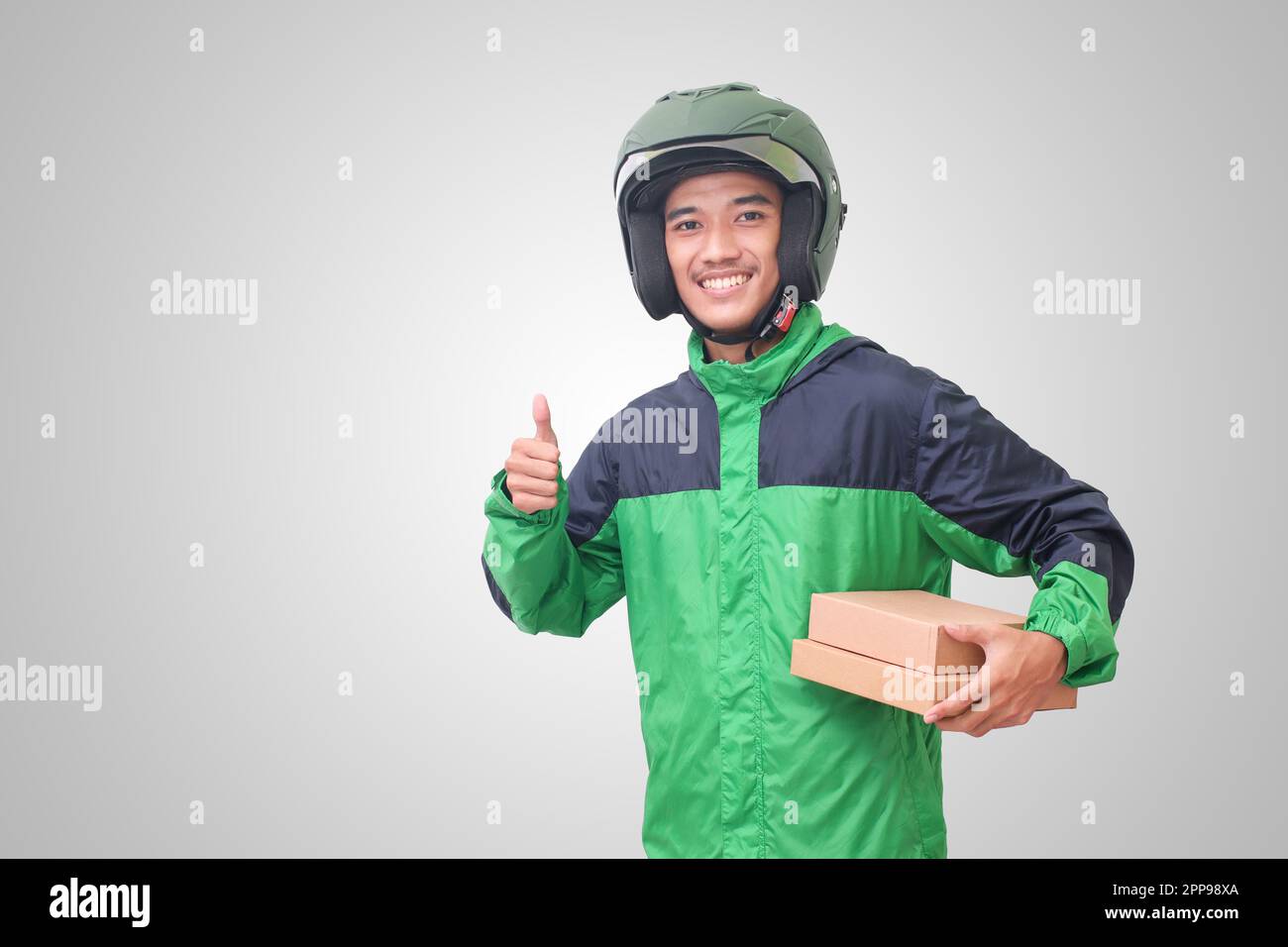 Portrait of Asian online courier driver wearing green jacket and helmet ...