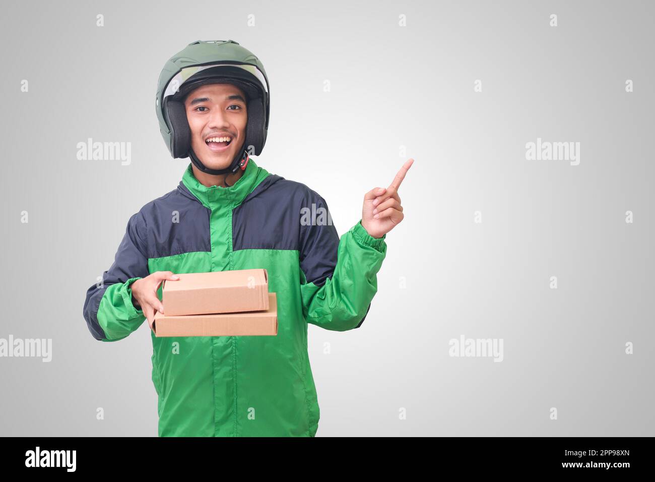 Portrait of Asian online courier driver wearing green jacket and helmet ...