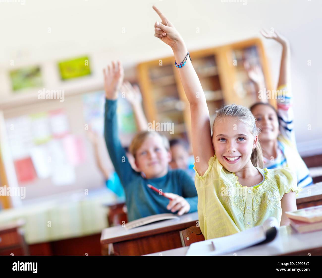 We know the answer. A group of school children raising their hands in ...