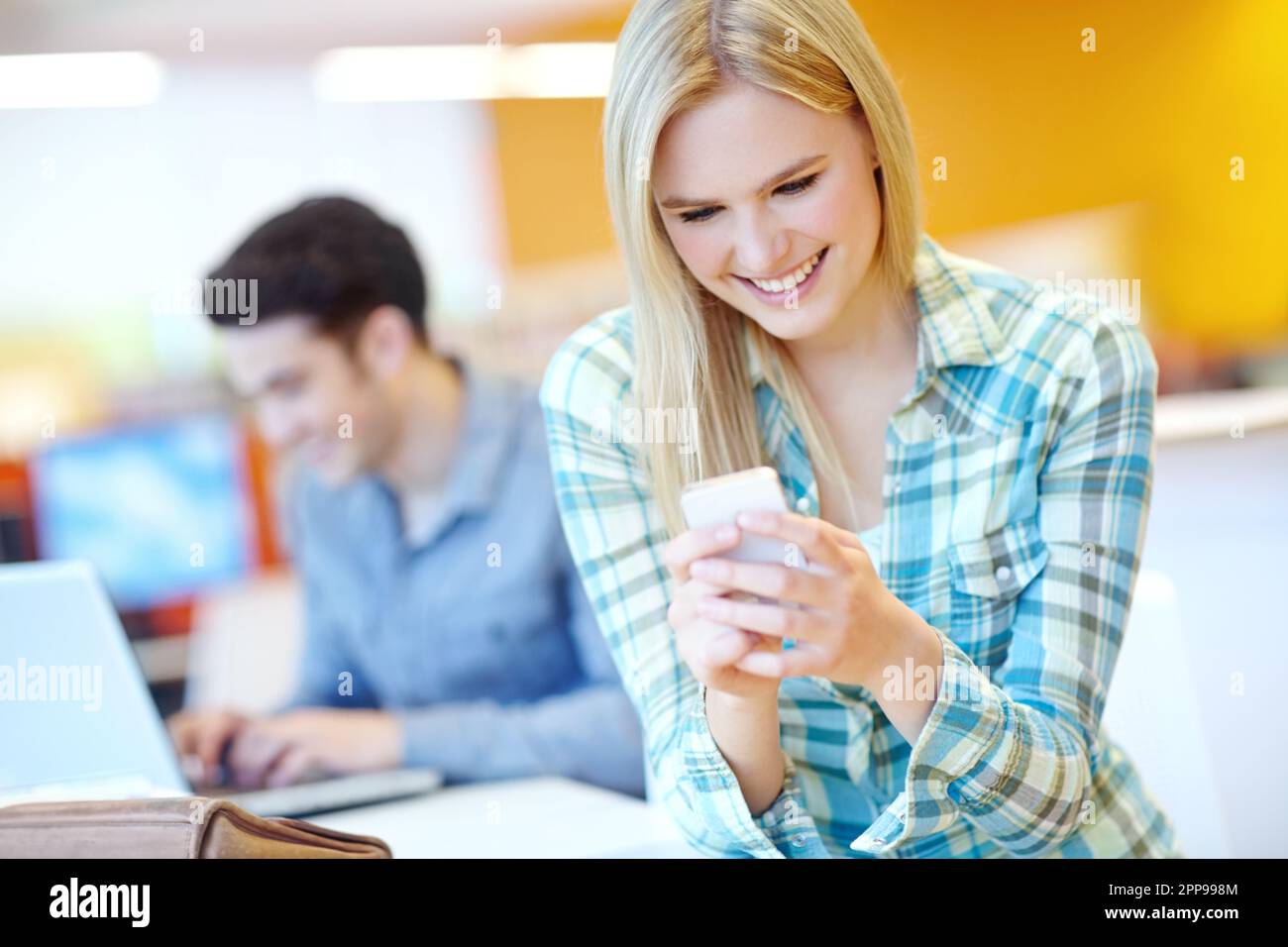 Keeping in contact with her friends. Attractive female student reading ...