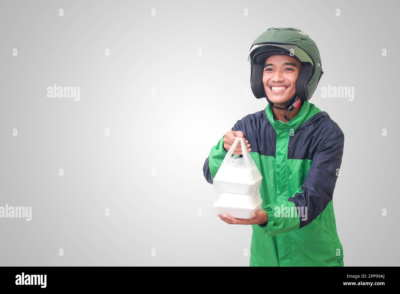 Portrait of Asian online taxi driver wearing green jacket and helmet ...