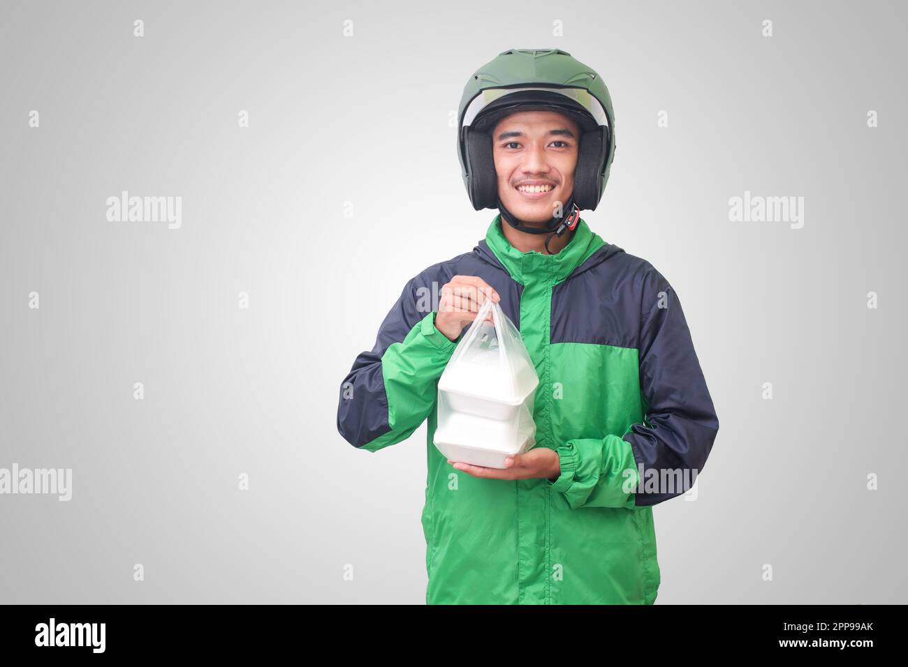 Portrait of Asian online taxi driver wearing green jacket and helmet ...
