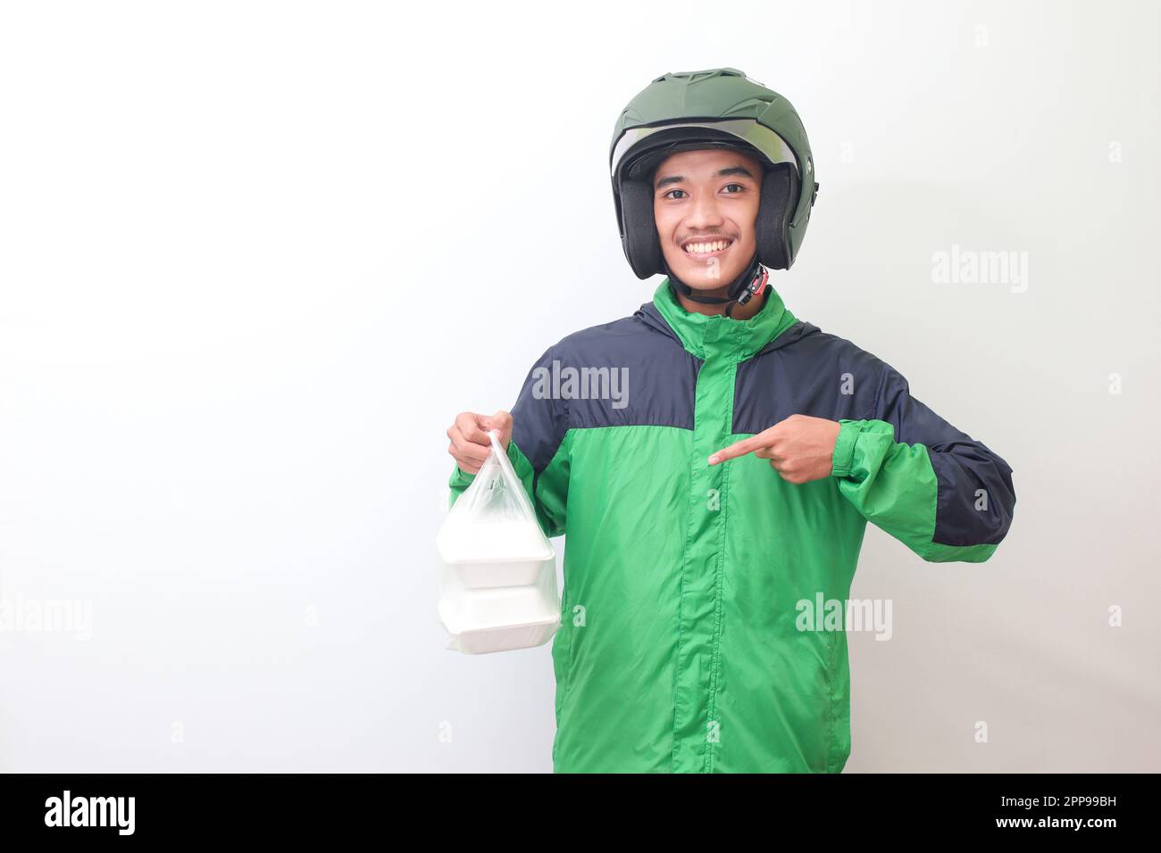 Portrait of Asian online taxi driver wearing green jacket and helmet ...