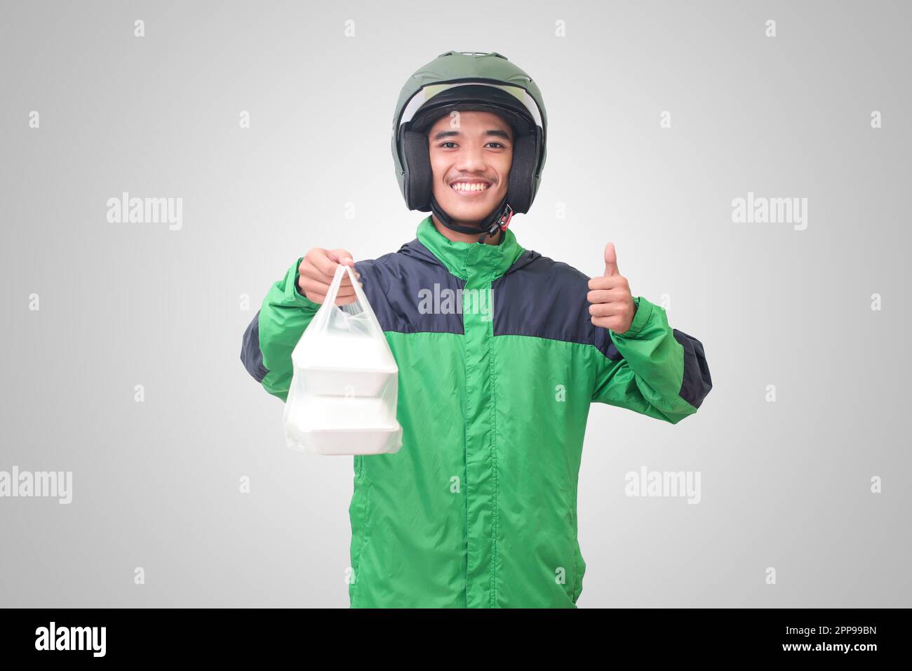 Portrait of Asian online taxi driver wearing green jacket and helmet ...