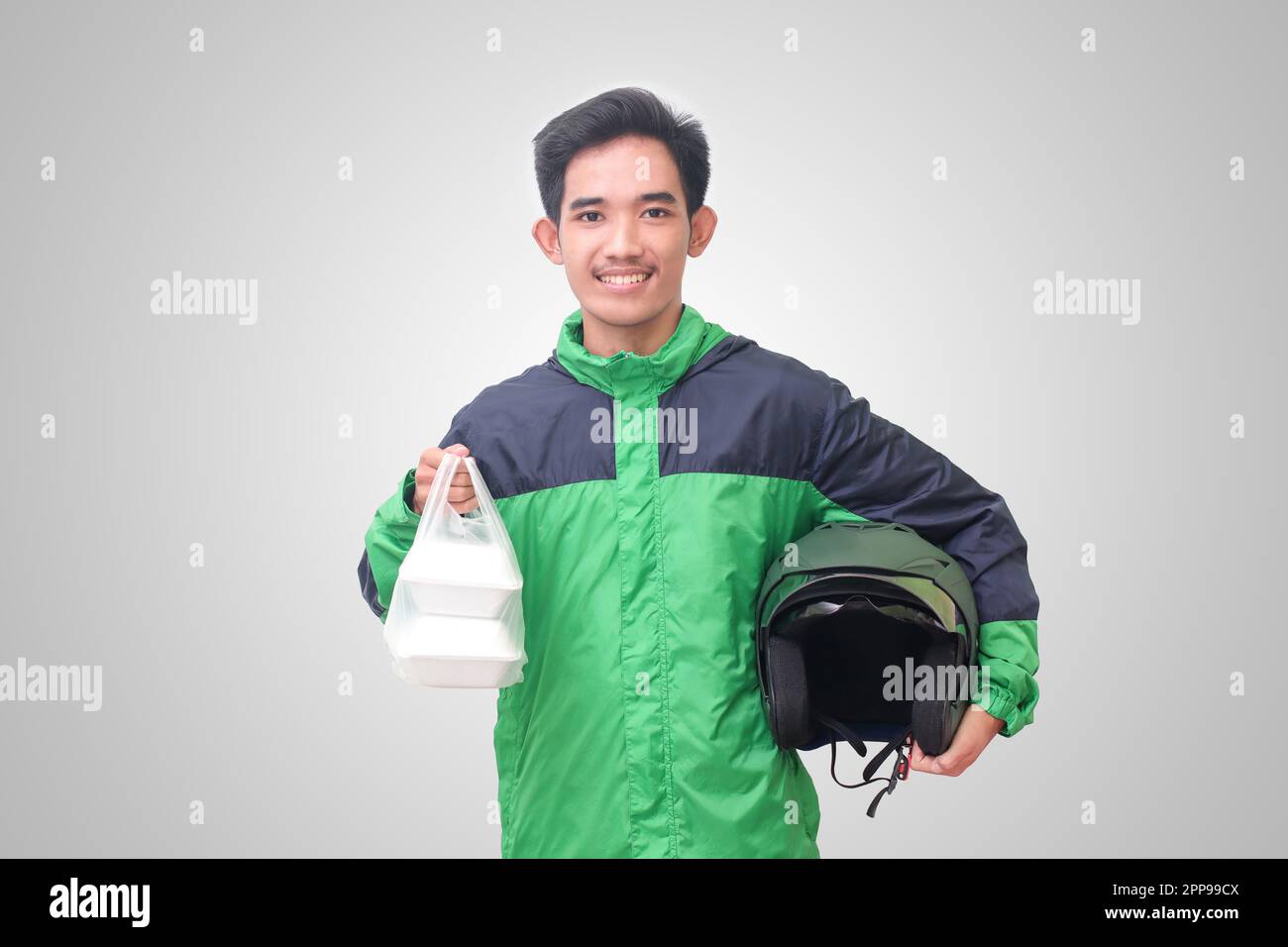 Portrait of Asian online taxi driver wearing green jacket and helmet ...