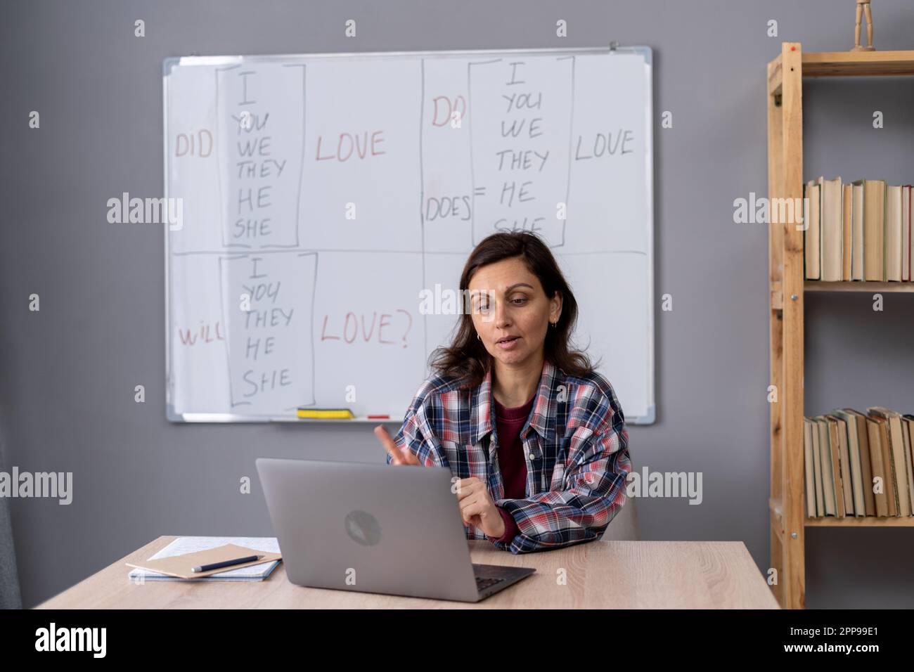 Mature teacher having online class through video call and explaining ...