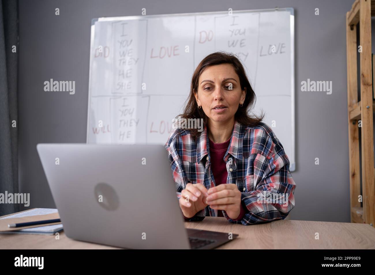 Professional female English teacher or tutor having video call ...