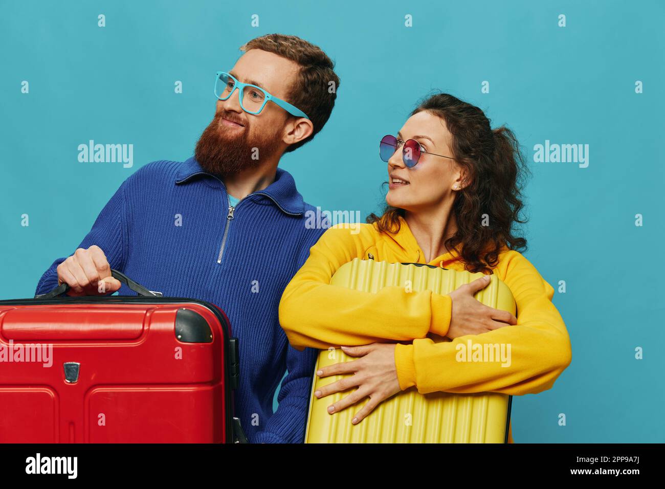 Woman and man smile suitcases in hand with yellow and red suitcase ...