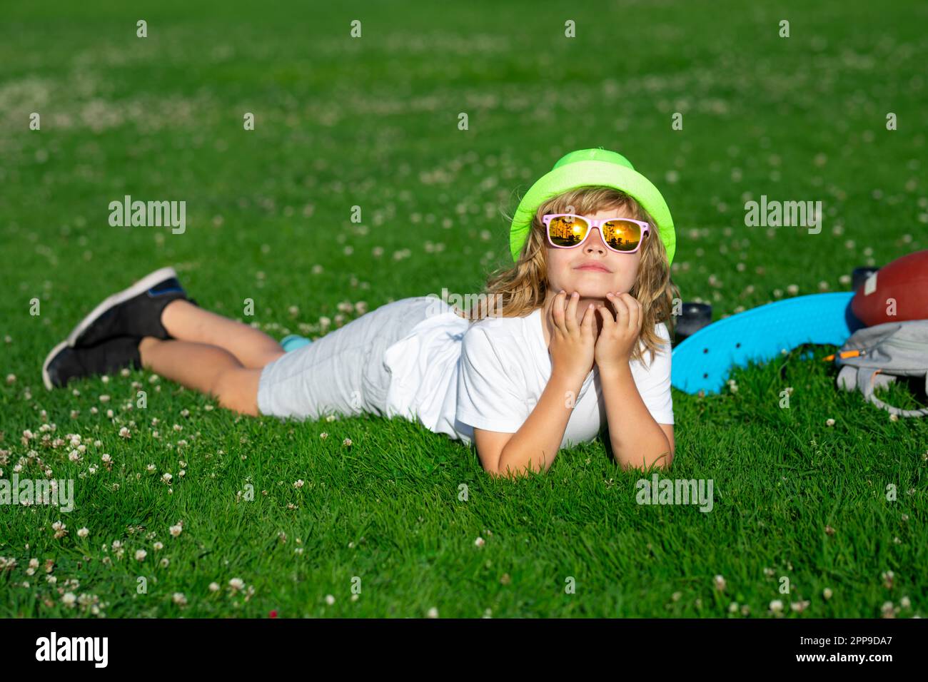 Kid on nature. Child relax at the summer park. Kid boy lying on green ...