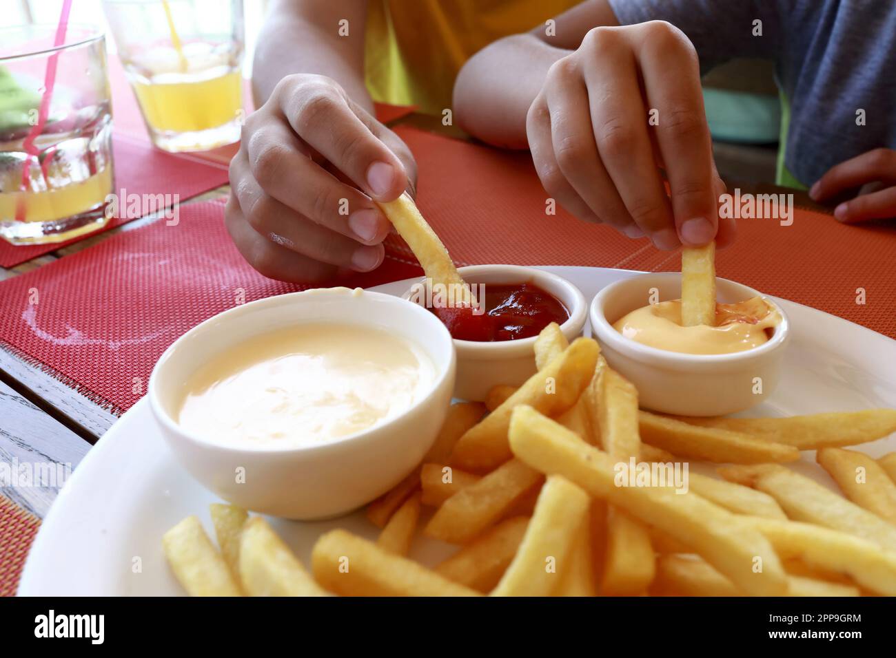 People dipping french fries in various sauces in restaurant Stock Photo ...