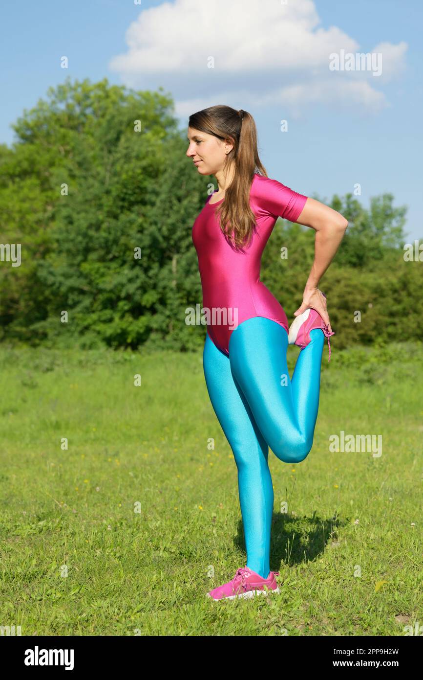 Woman wearing fitness outft in the 80s/90s style, stretching exercises ...