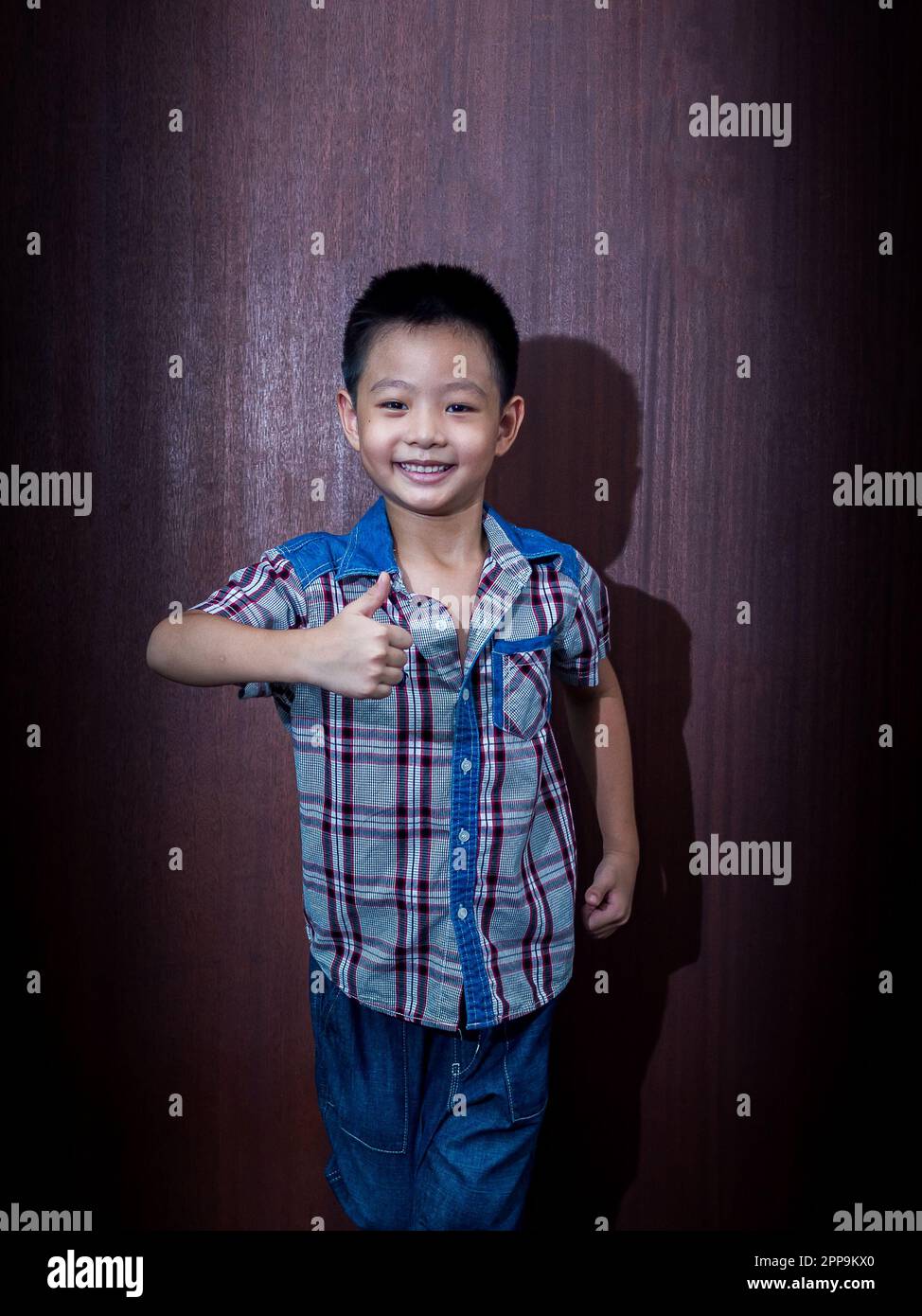 little cute boy on wood background gesture smiling closeup, thumbs up ...