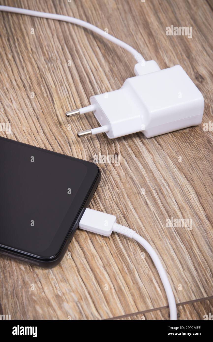 Black smartphone, mobile phone and charger using to charge empty ...