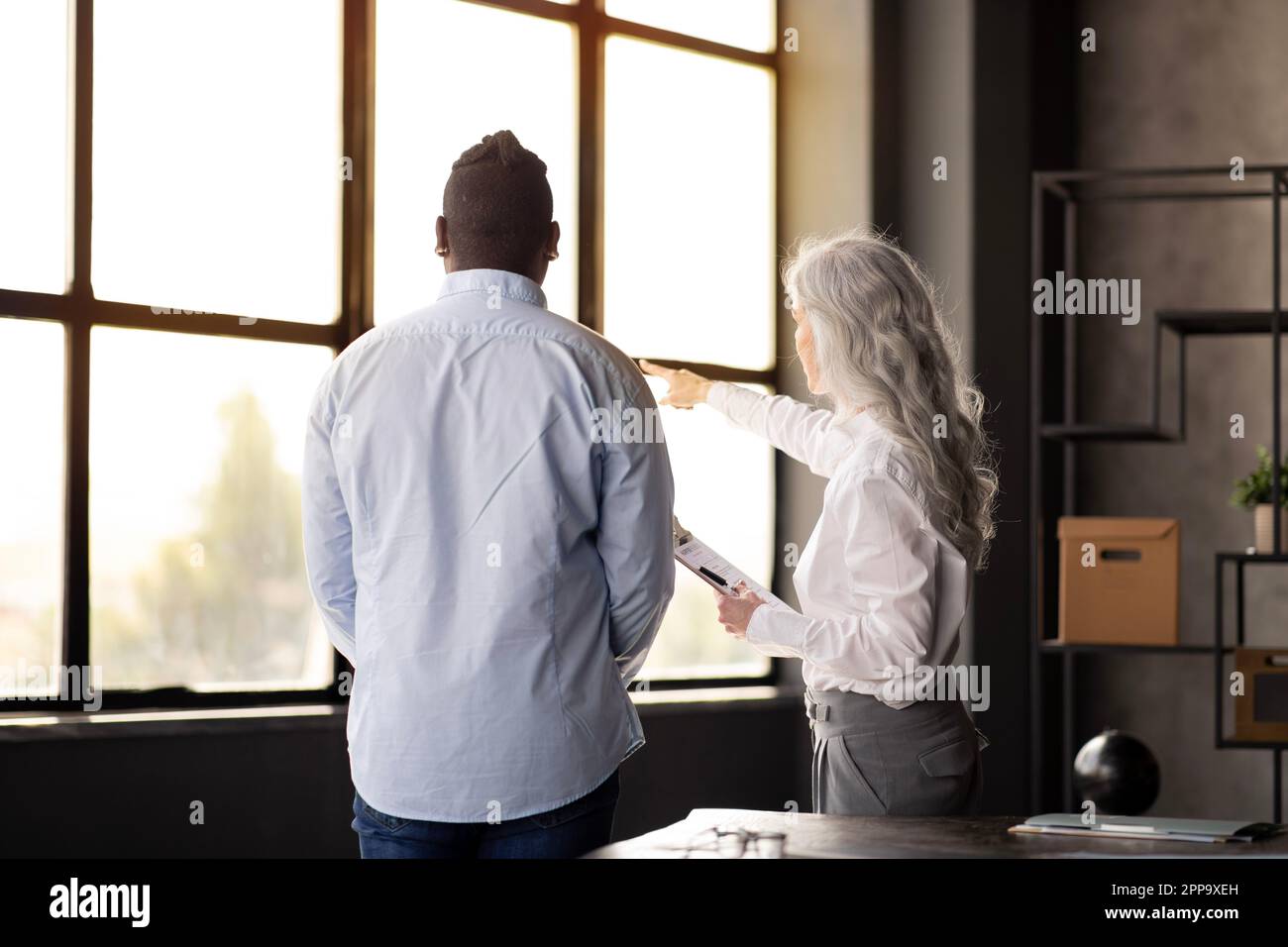Female Talking With Male Pointing Finger At Window In Office Stock ...