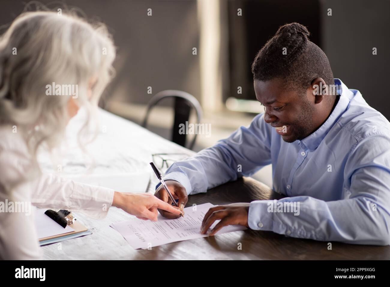 Black lady signing papers hi-res stock photography and images - Alamy