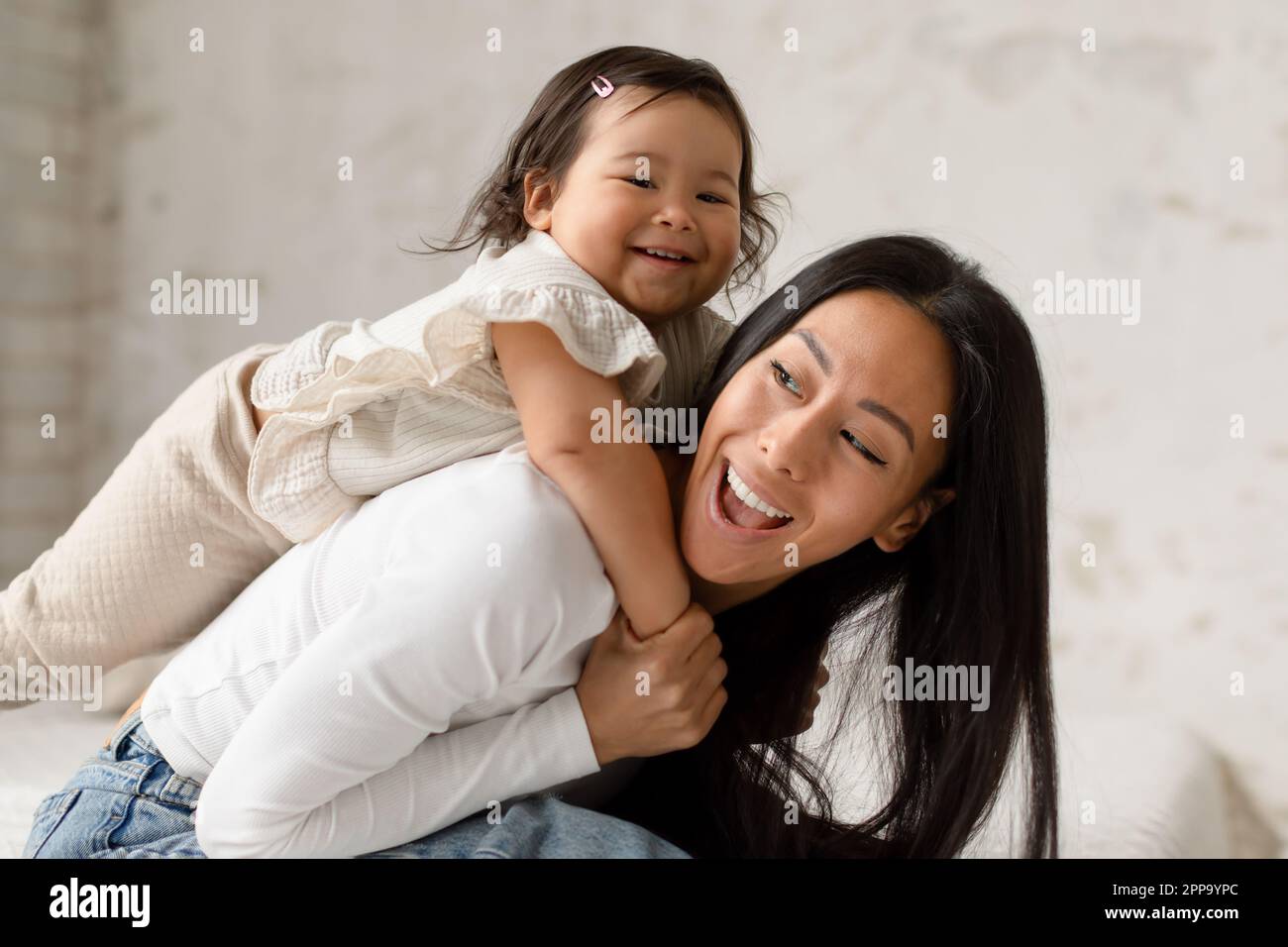 Girl riding piggyback on mother hi-res stock photography and images - Alamy