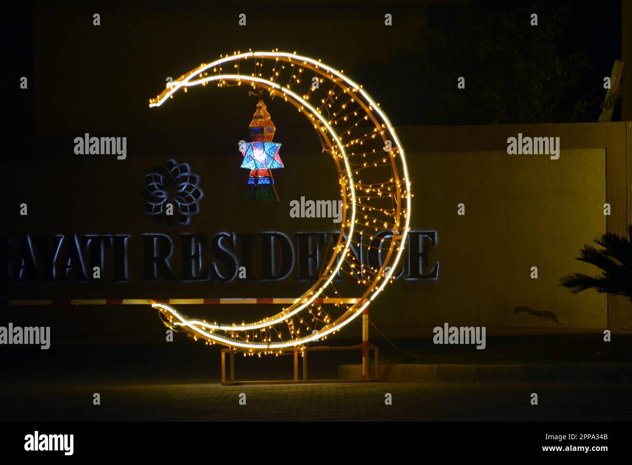 Cairo, Egypt, April 17 2023: A crescent made with led lights with Ramadan Fanous lamp lantern in ...