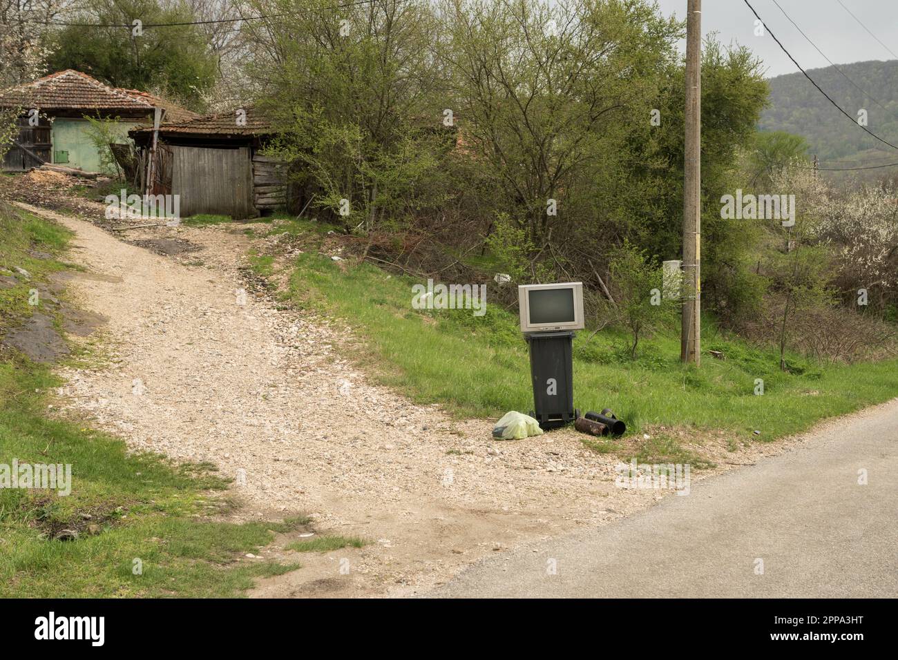 Discarded TV on top of trash can at countryside road Stock Photo - Alamy
