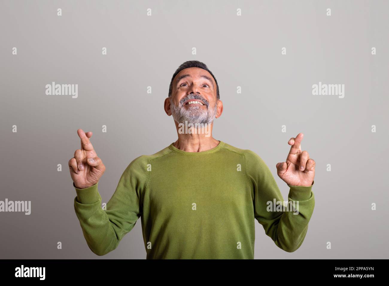 Cheerful curios old european man with beard shows fingers up on empty ...