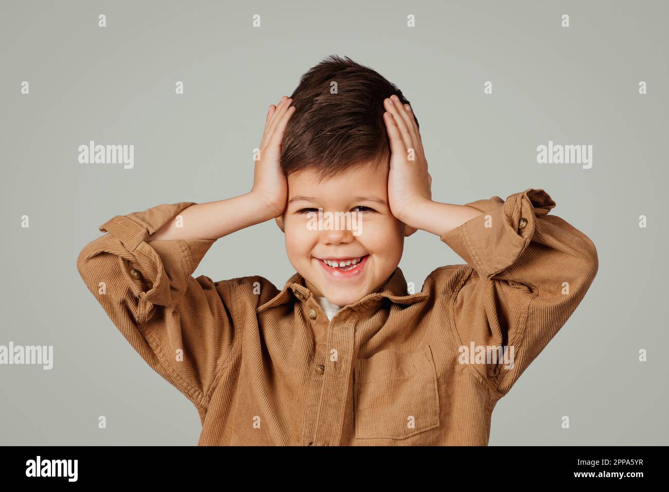 Positive shocked caucasian small child 6 years old in shirt looks at ...