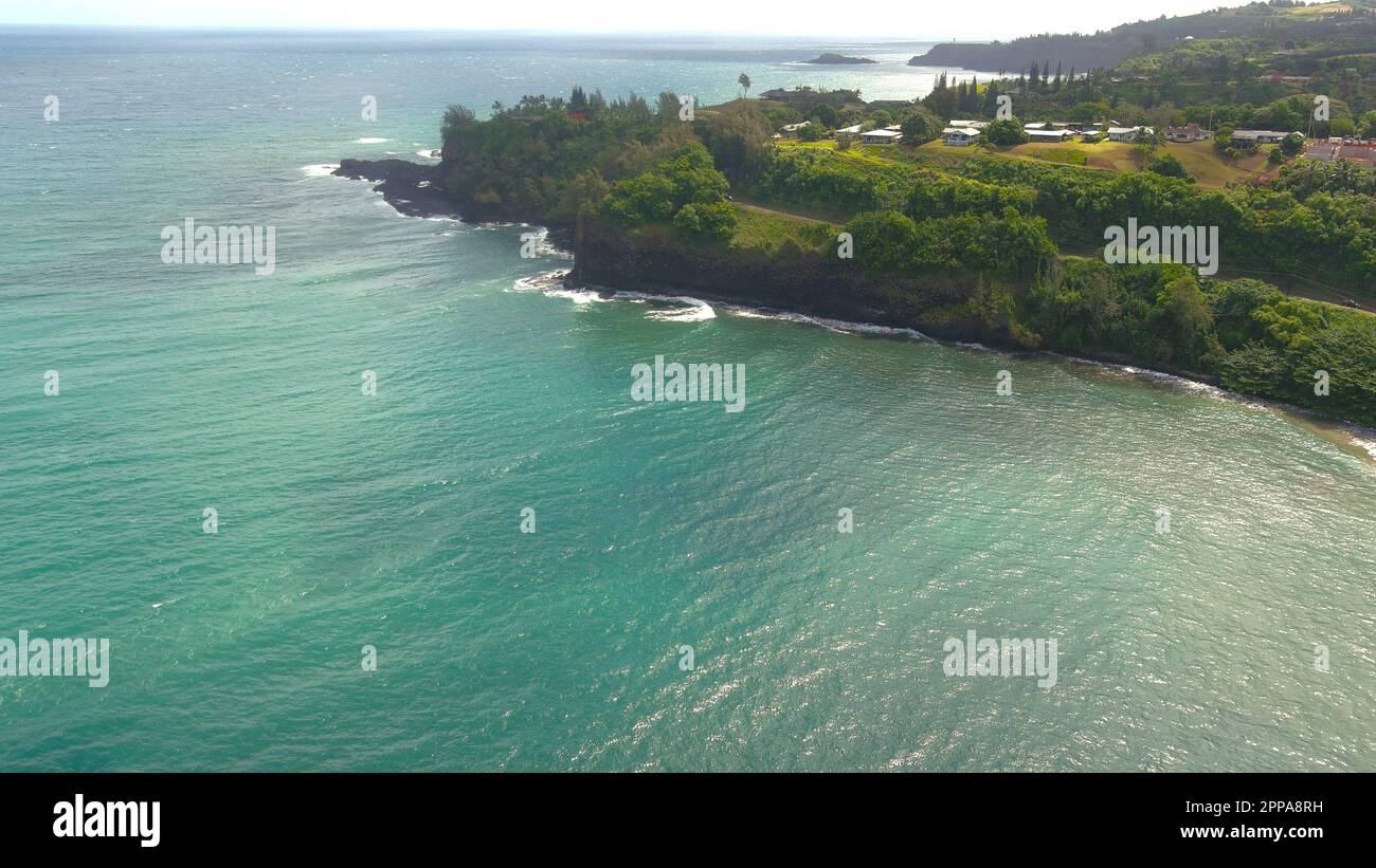 An aerial view of a tropical beach with crystal-clear water in Kauai ...