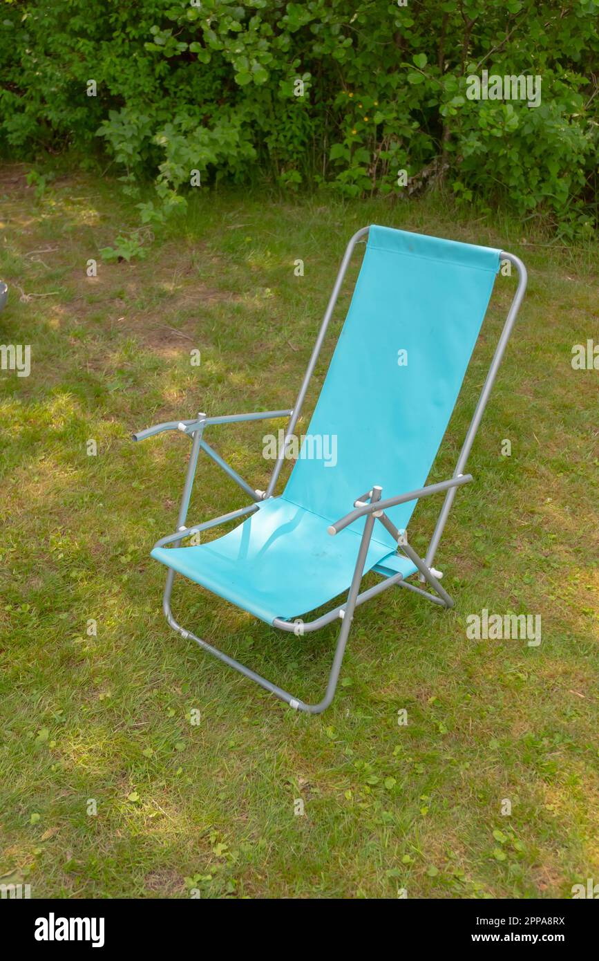 A blue beach chair placed in the shadow in a park Stock Photo - Alamy