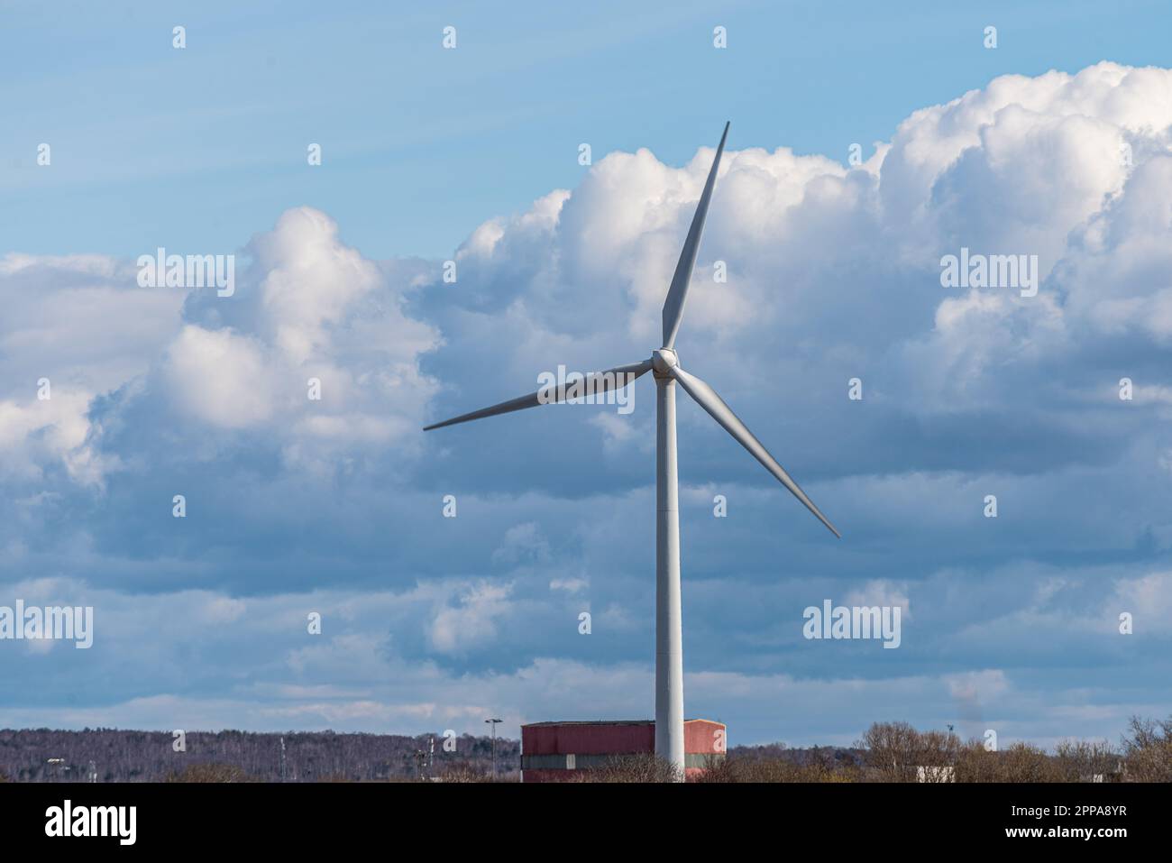 Wind turbine by industrial buildings Stock Photo - Alamy