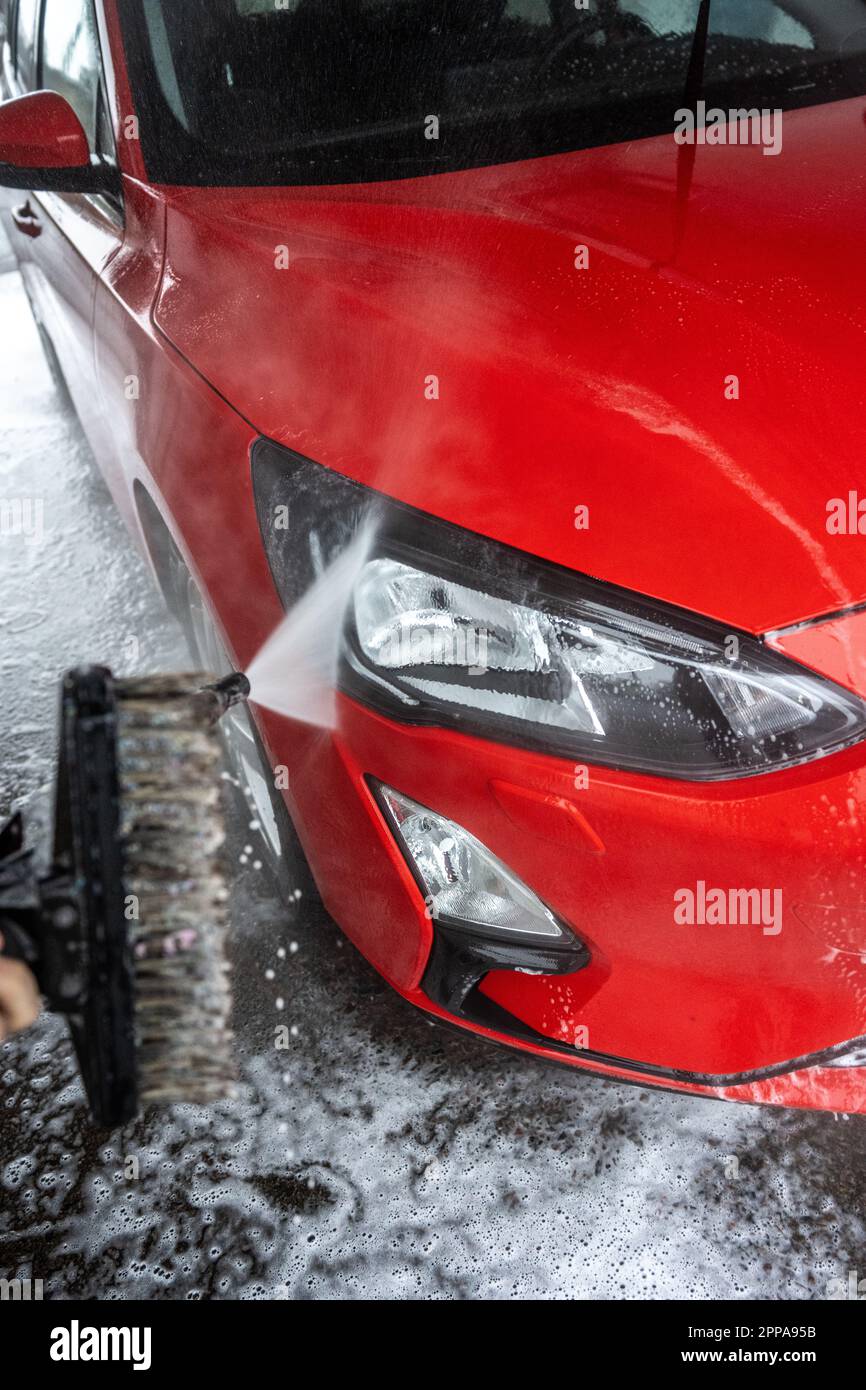 Front lights of a red car being washed Stock Photo - Alamy