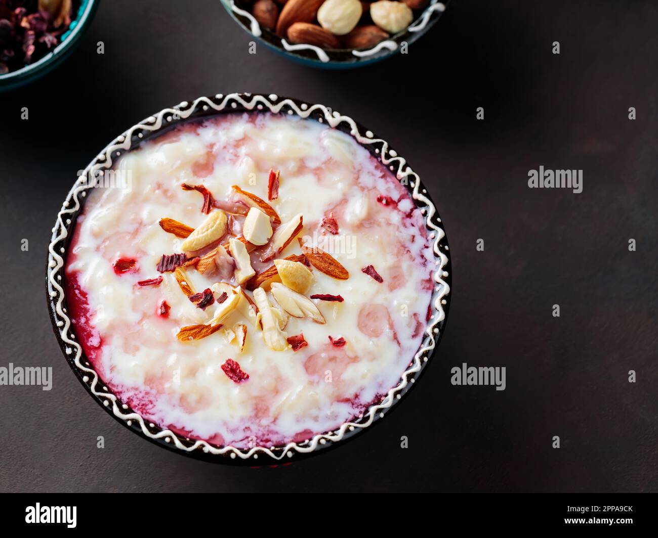 Rice kheer with sprinkled nuts on dark background. Rice pudding served ...